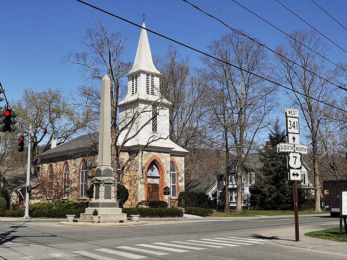 Charming Kent streets welcome you with this historic stone church and its iconic steeple standing tall against the bright blue sky.