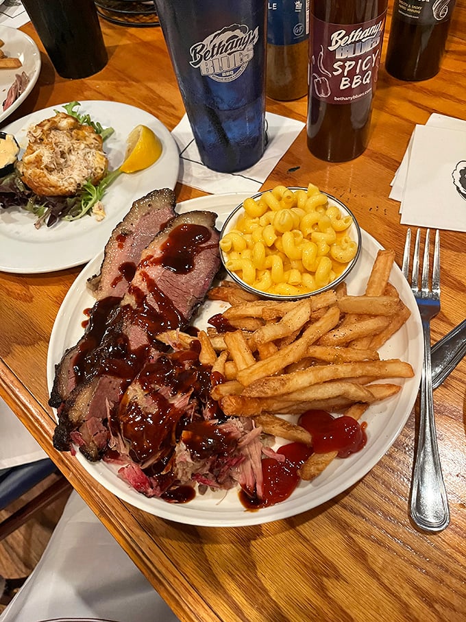 Behold the holy trinity of barbecue bliss: tender brisket, golden mac and cheese, and crispy fries. The sauce is just showing off.
