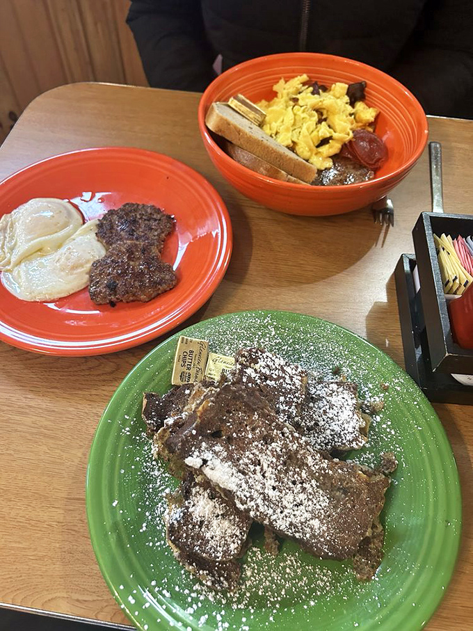 A breakfast trinity: eggs, sausage, and French toast dusted with powdered sugar&mdash;proof that good things really do come in threes.