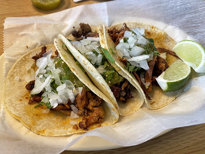 Barbacoa tacos that could make a vegetarian question their life choices, topped with fresh pico de gallo and slices of creamy avocado.