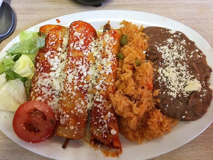 The holy trinity of Mexican comfort: enchiladas, rice, and beans. That sprinkle of queso fresco is like a dusting of edible confetti.