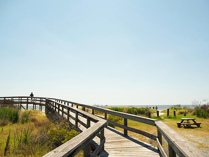The pathway to paradise isn't paved. This wooden boardwalk crosses coastal dunes like a bridge between everyday life and the timeless rhythm of waves ahead.