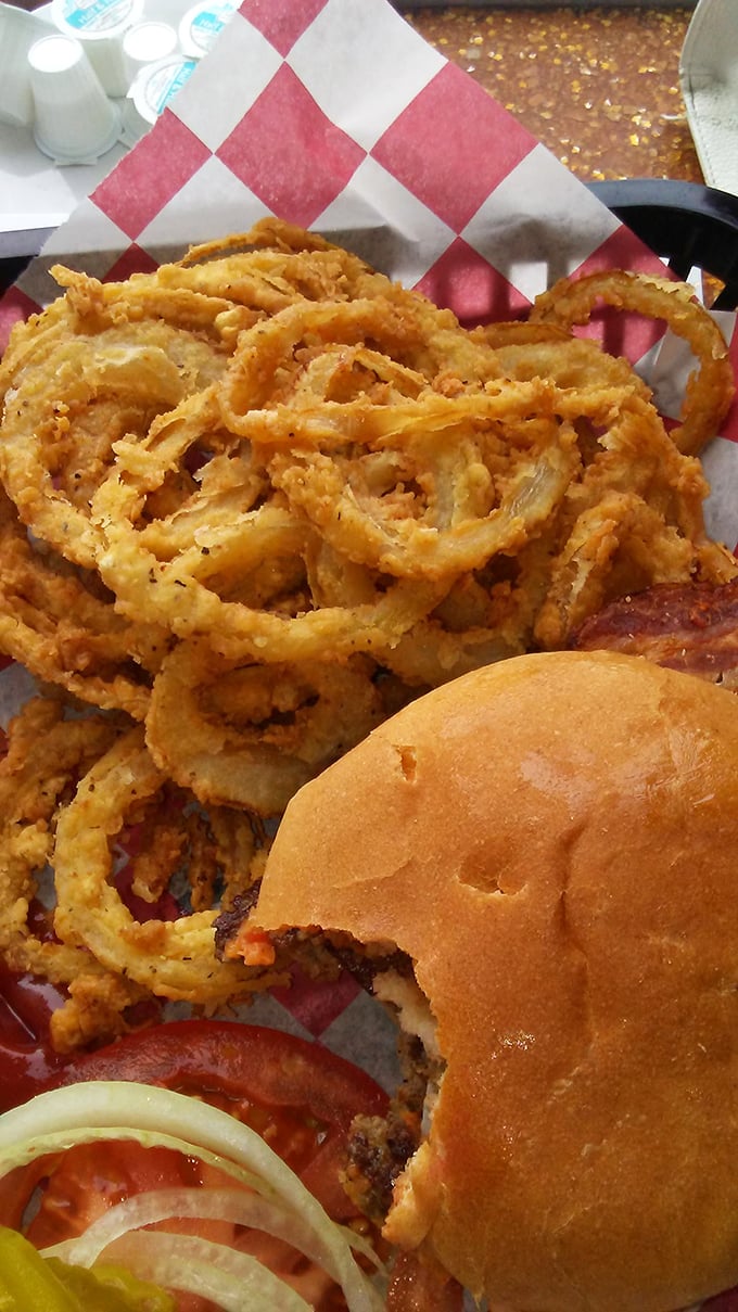 The golden architecture of those onion rings deserves its own preservation society. Paired with that perfectly toasted bun, it's a masterclass in diner perfection.