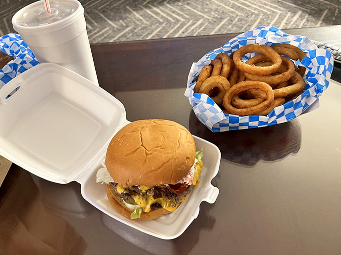The artful pairing of a fully-loaded burger and golden onion rings&mdash;proof that some relationships are simply meant to be, wrapped in checkered paper rather than romance novels.