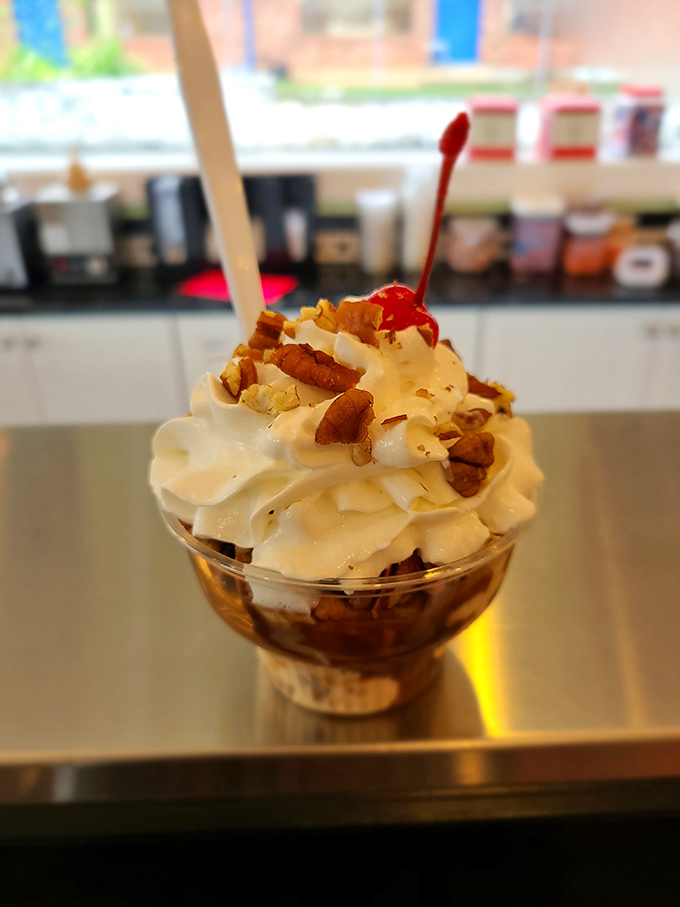 This sundae isn't just dessert; it's engineering brilliance with whipped cream, pecans, and that perfectly placed cherry on top.