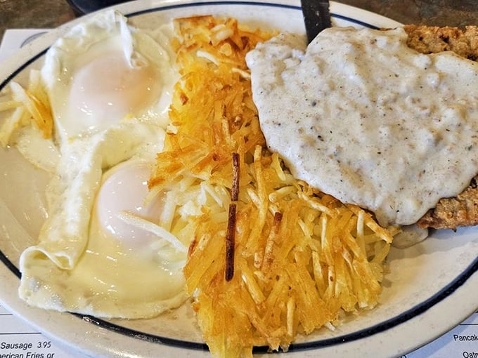 Breakfast nirvana: golden hash browns, perfectly fried country steak with gravy, and eggs sunny-side up &ndash; the holy trinity of diner breakfast excellence.
