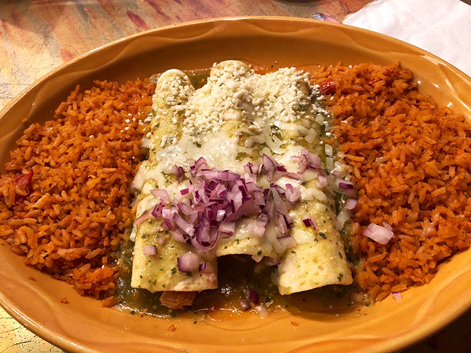 These enchiladas verdes sport purple onions like a jaunty beret. The sauce, a vibrant green blanket, promises tanginess that makes taste buds stand at attention.