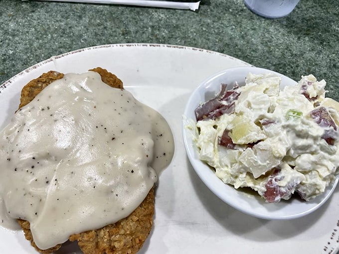 Behold: the perfect marriage of crispy and creamy. This chicken fried steak with its blanket of pepper gravy alongside homemade potato salad is what comfort food dreams are made of.