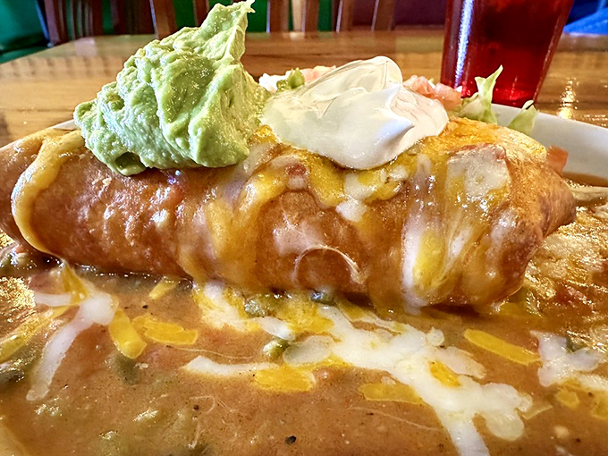 Meet the star of the show: a golden-brown chimichanga lounging in a pool of sauce, topped with guacamole that looks like it was made minutes ago.