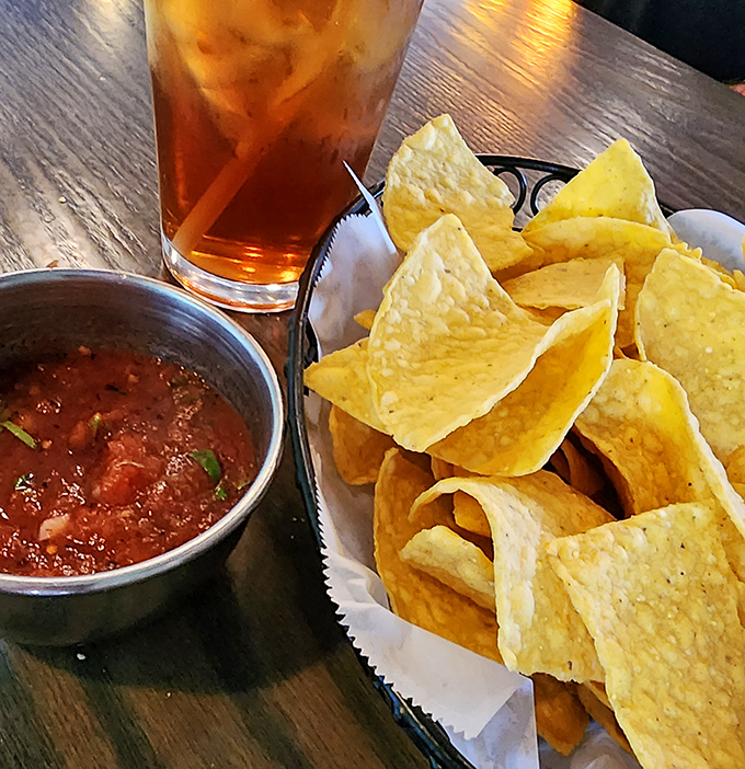The holy trinity of Mexican restaurant starters: perfectly crisp chips, salsa with actual personality, and an iced tea tall enough to survive the Texas heat.