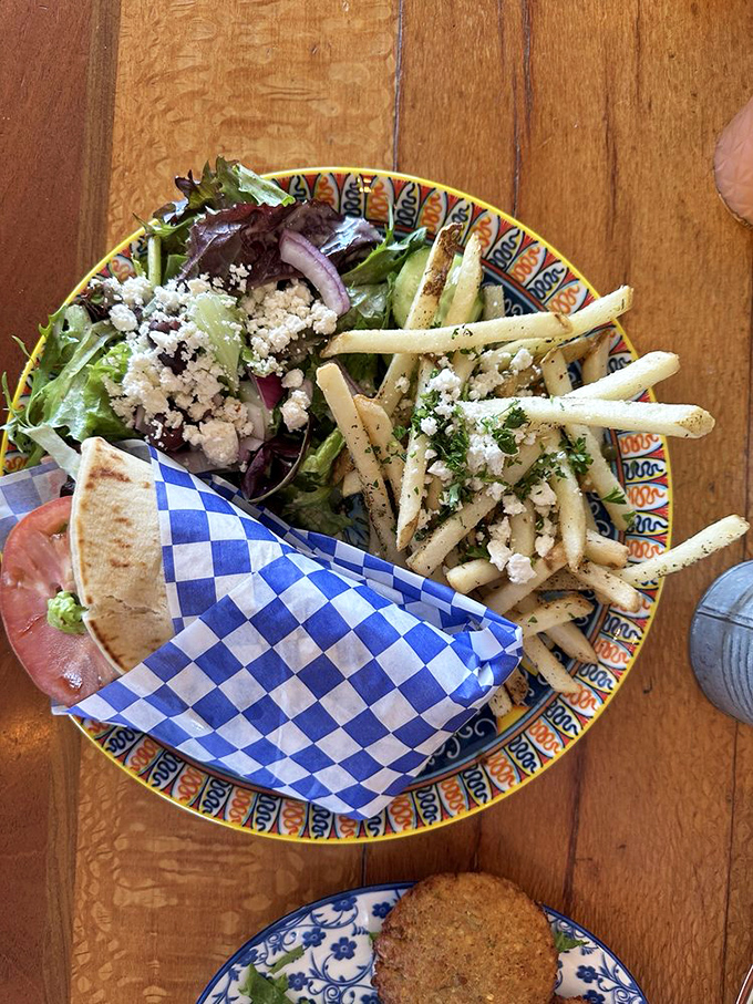 The perfect trifecta: a gyro wrapped in checkered paper, Greek salad with generous feta crumbles, and fries that could start their own fan club.