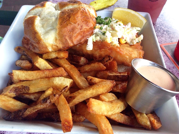 The fish sandwich arrives like Neptune's gift to carb-lovers, with golden fries standing at attention, ready for their dipping destiny.