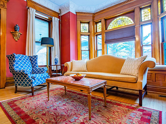 A sitting room that perfectly balances Victorian elegance with "please actually sit here" comfort. That blue chair is practically begging for a good book.