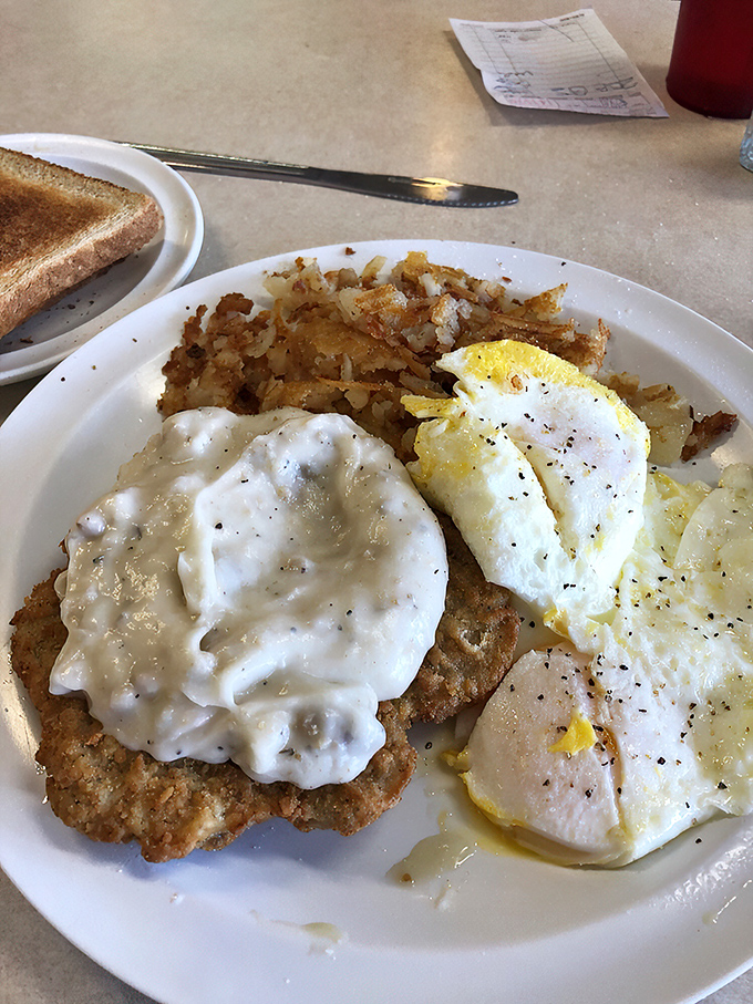 The star of the show: golden-fried country steak blanketed in creamy pepper-speckled gravy alongside sunny eggs that could brighten even Monday mornings.