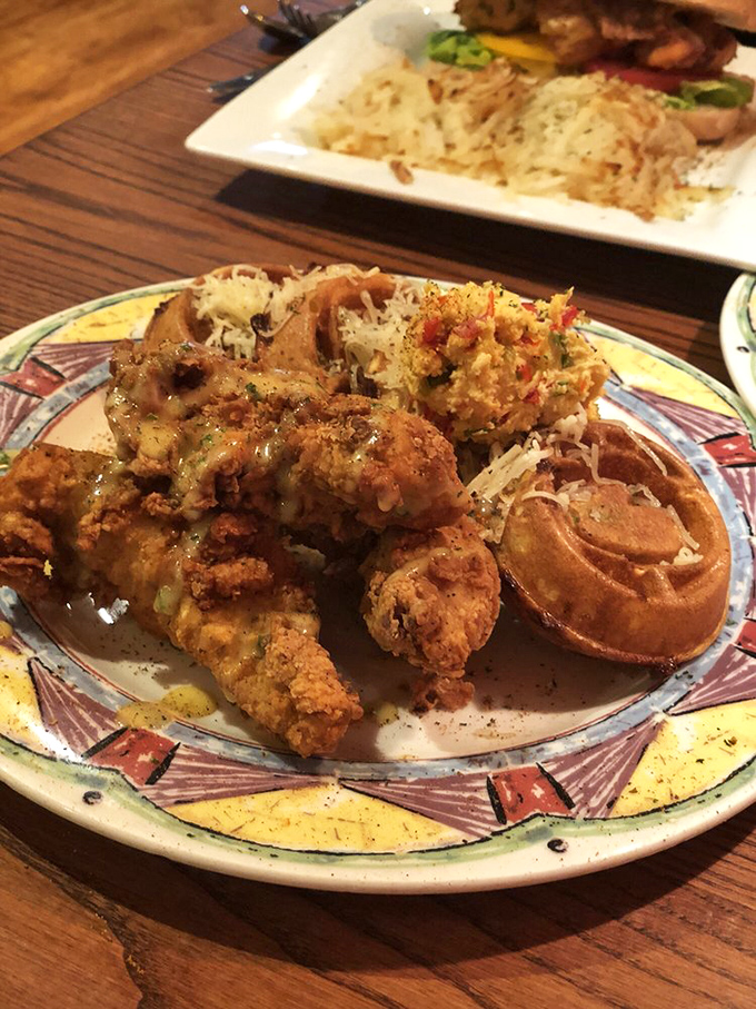 Crispy, seasoned chicken meets sweet, fluffy waffles in a plate romance that's lasted longer than most Hollywood marriages. The cheese garnish adds a savory plot twist.