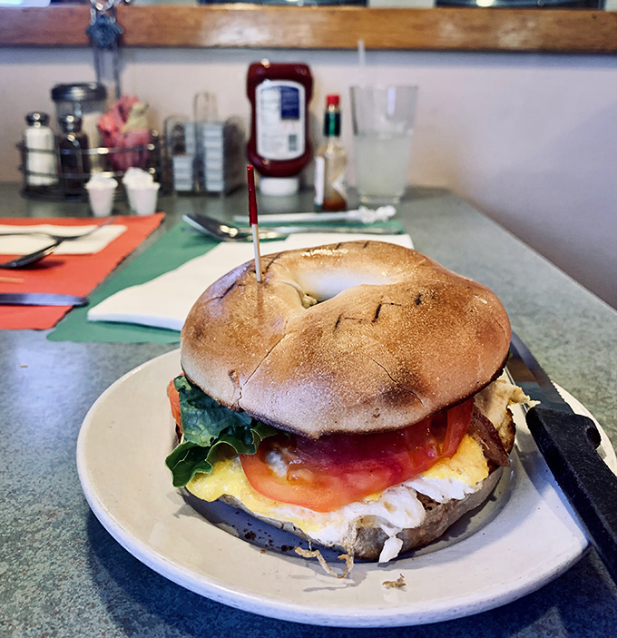 This isn't just a sandwich; it's architecture. A towering breakfast bagel creation that makes you wonder if you should eat it or take a picture first.
