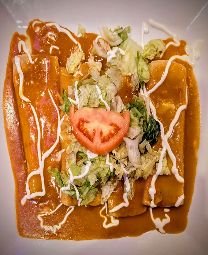 These enchiladas aren't just covered in sauce&mdash;they're embraced by it, topped with fresh greens and a tomato slice that's basically wearing a flavor crown.