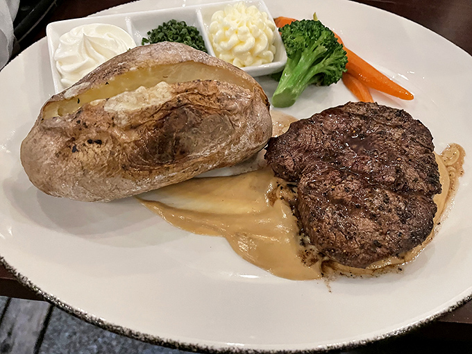 The holy trinity of steakhouse perfection: a juicy filet, creamy mashed potatoes, and vegetables that somehow make you feel virtuous while indulging.