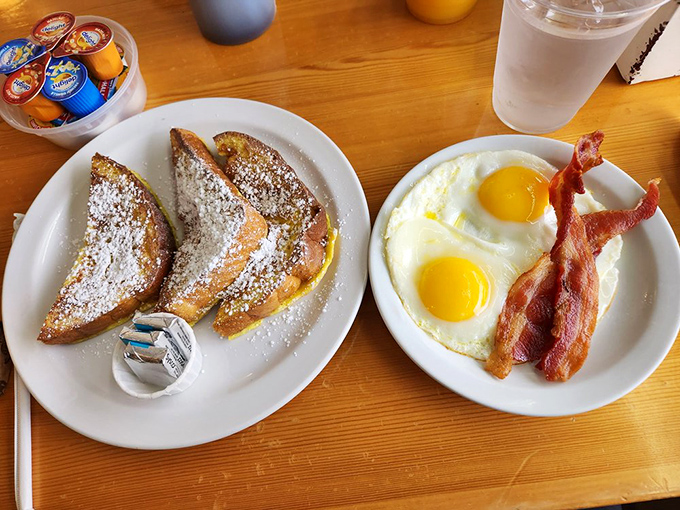 The holy trinity of breakfast: French toast that's crisp-edged yet custardy inside, sunny-side-up eggs with vibrant yolks, and bacon cooked to that perfect crispy-chewy balance.