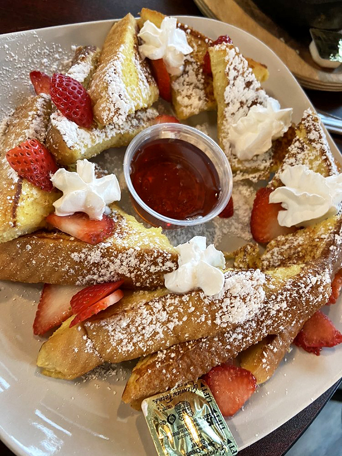 The strawberry French toast arrives like edible architecture—a beautiful arrangement of custard-soaked bread, fresh berries, and cream that's practically begging for its Instagram moment.