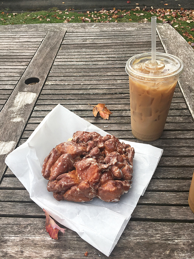 The perfect autumn breakfast doesn't exi&mdash; wait, is that an apple fritter and iced coffee on a weathered picnic table? 