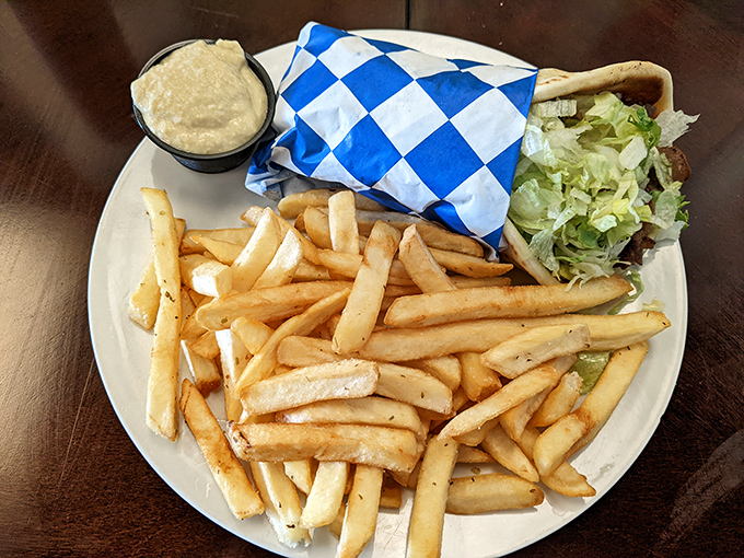 The classic gyro and fries combo arrives like an old friend&mdash;reliable, comforting, and wrapped in that blue-checkered paper that signals good things ahead.