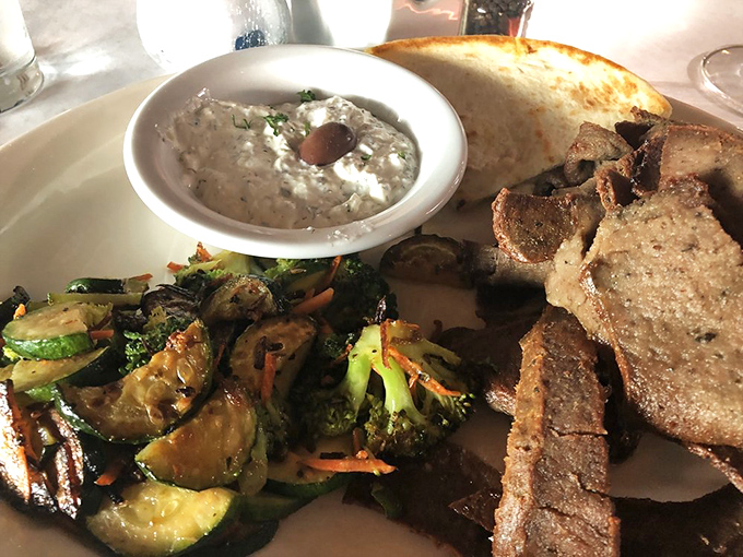 A plate that speaks fluent Greek: perfectly seasoned gyro meat, cooling tzatziki, and grilled vegetables that would make Zeus himself put down his thunderbolt.