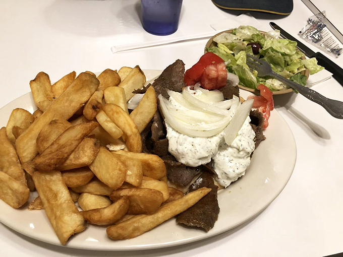 The holy trinity of Greek dining: perfectly seasoned gyro meat, hand-cut fries, and a Greek salad that actually tastes like someone cares. Simplicity at its most delicious.