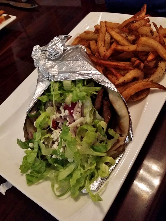 The perfect marriage: a gyro wrapped in foil like a present, alongside fries that could make a Greek grandmother nod in approval.