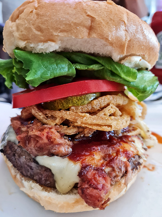 This isn't just a burger; it's an architectural masterpiece of beef, bacon, cheese, and fresh toppings that requires both hands and zero shame.