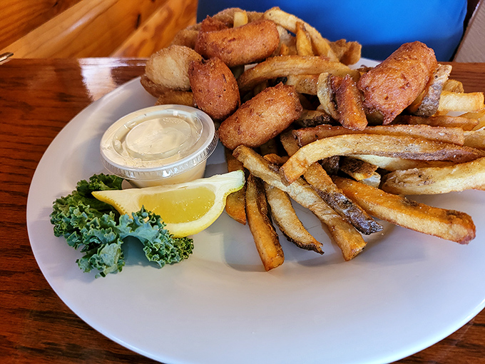 The perfect marriage: crispy hush puppies and hand-cut fries sharing a plate like old friends, with tartar sauce playing matchmaker.