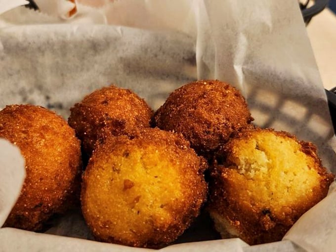 Golden hush puppies that crackle with each bite, revealing a tender cornmeal interior that whispers, "Slow down, sugar. Savor me."