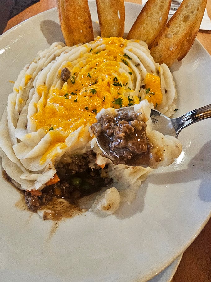 One fork dive reveals the shepherd's pie's hidden treasure – savory meat and vegetables nestled beneath that cloud of buttery potato perfection.