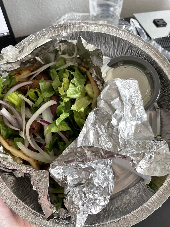 Peek inside this aluminum treasure chest and discover a gyro packed with fresh veggies, seasoned meat, and that tzatziki sauce you'll be dreaming about tomorrow.
