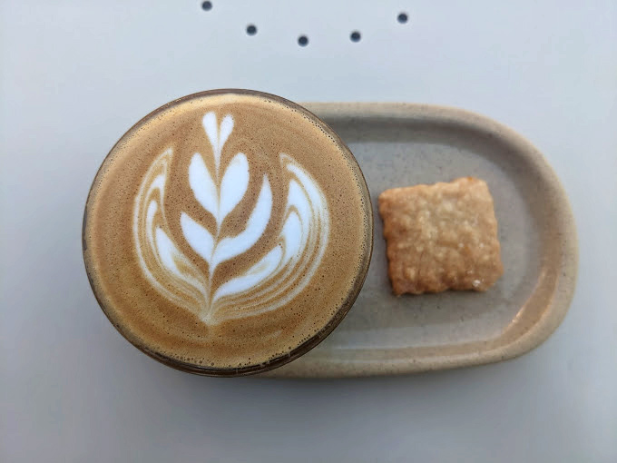 A perfect latte paired with a shortbread cookie—proof that sometimes the simplest combinations are life's greatest pleasures.