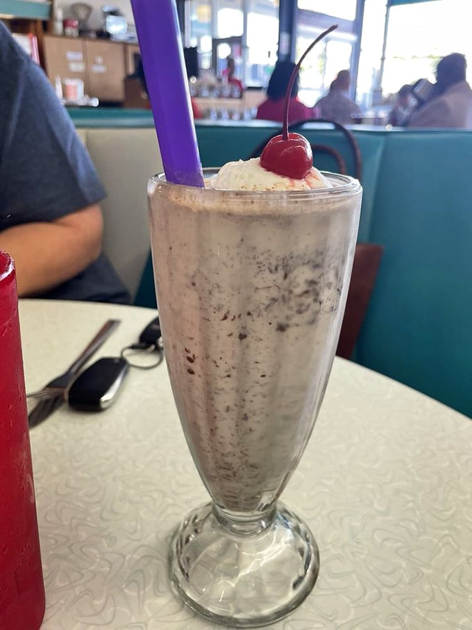 This cookies-and-cream masterpiece stands tall like a Mississippi monument to dairy perfection, complete with ceremonial cherry.