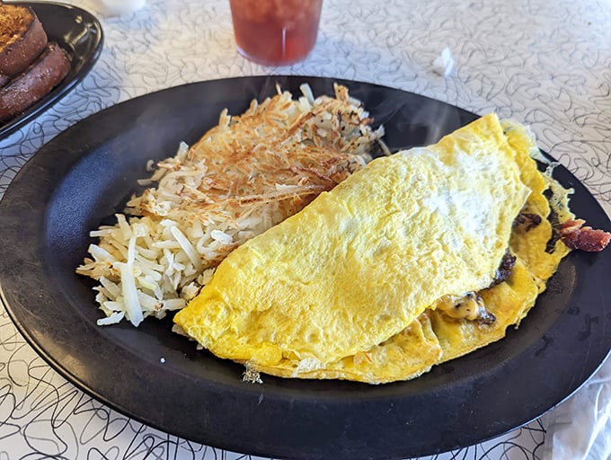 An omelet so fluffy it practically floats above the plate, paired with hash browns that achieve the perfect crisp-to-tender ratio.