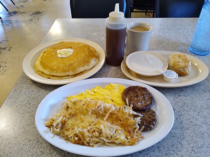 That pancake looks like it's auditioning for a breakfast cereal commercial&mdash;golden, fluffy, and ready for its syrup shower. The sausage patties stand guard, ensuring no bite goes unflavored.