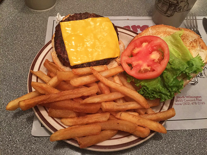 The Pit Deluxe Burger arrives like a work of art&mdash;golden cheese cascading over charbroiled beef, with fries standing at attention nearby.
