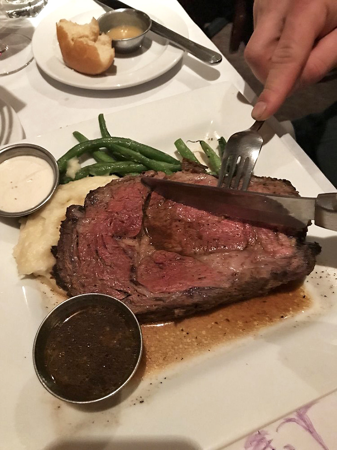 A knife might seem unnecessary for this fork-tender prime rib, served with creamy mashed potatoes and asparagus in a pool of savory au jus.
