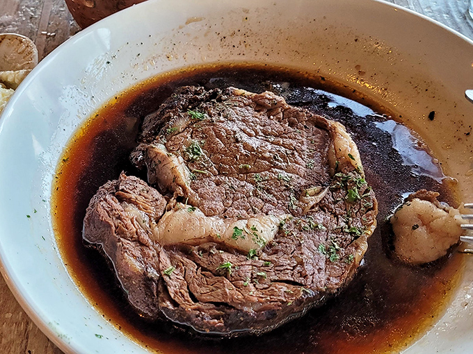 The prime rib's perfect pink center surrounded by that seasoned crust is the kind of sight that makes conversation halt mid-sentence.