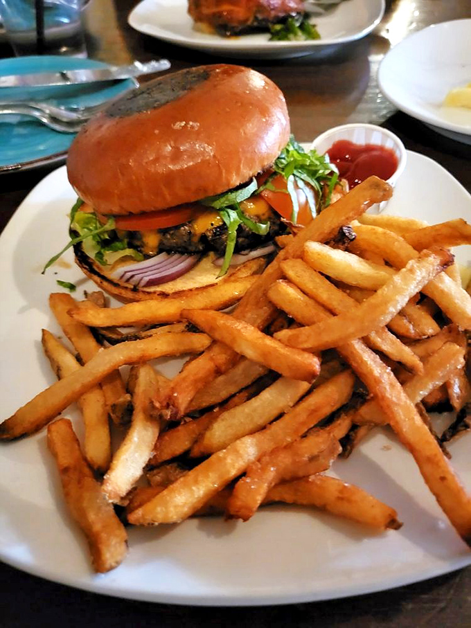The Pub Burger arrives like a delicious skyscraper of flavor, with fries so golden they deserve their own Fort Knox.