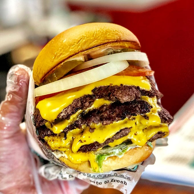 Layers upon layers of beefy goodness with American cheese cascading like a yellow waterfall—proof that some architectural marvels are edible.