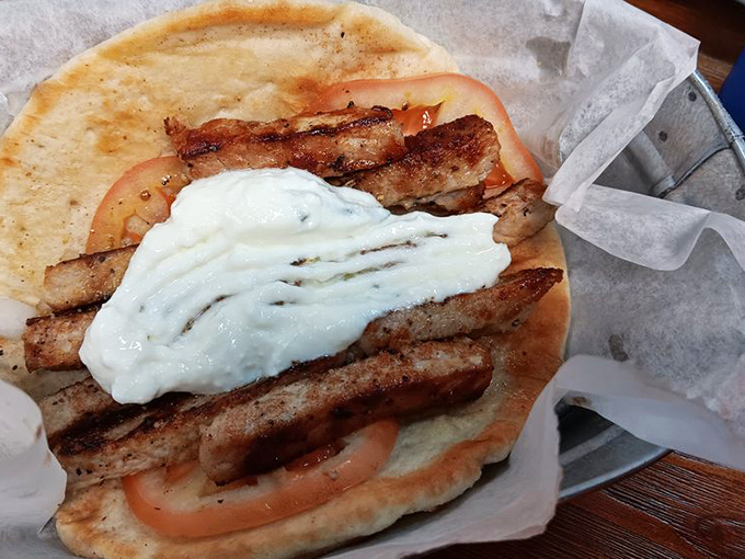 Souvlaki perfection: Seasoned meat strips lounging on a warm pita bed with tzatziki blanket. Comfort food that transcends continents.