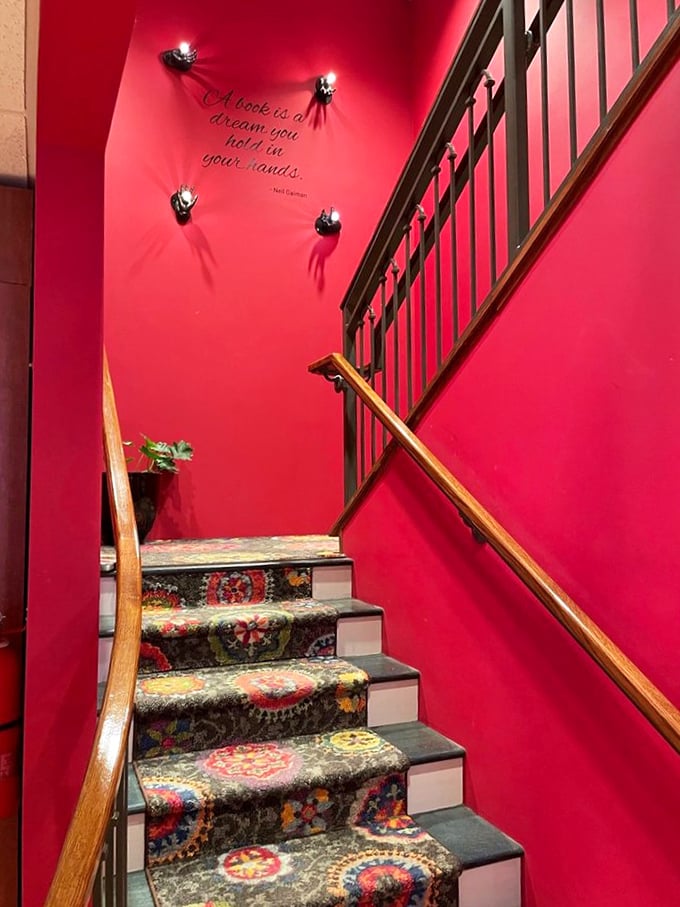 Even the staircase tells a story, with its vibrant carpet and Neil Gaiman's wisdom painted on crimson walls: "A book is a dream you hold in your hands."