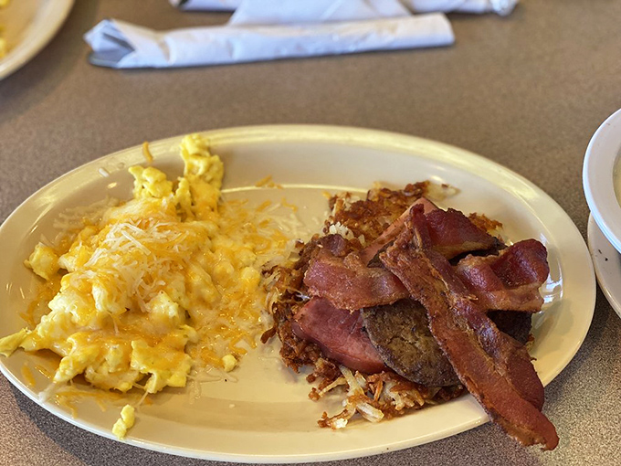 The breakfast plate that launched a thousand food comas. Golden hash browns, fluffy eggs, and crispy bacon create the breakfast trifecta that's worth every minute of the wait.