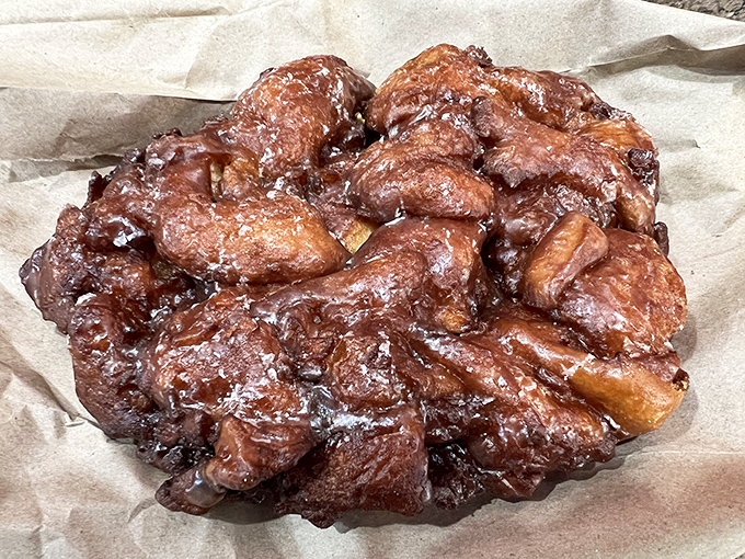This isn't just an apple fritter; it's a topographical map of deliciousness with chunks of real apple creating sweet little pockets of joy throughout.
