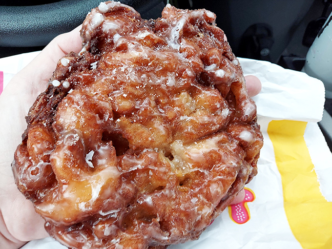 The Gibson's apple fritter in its natural habitat &ndash; balanced perfectly in hand, glistening with glaze that promises to leave evidence on your car's steering wheel.