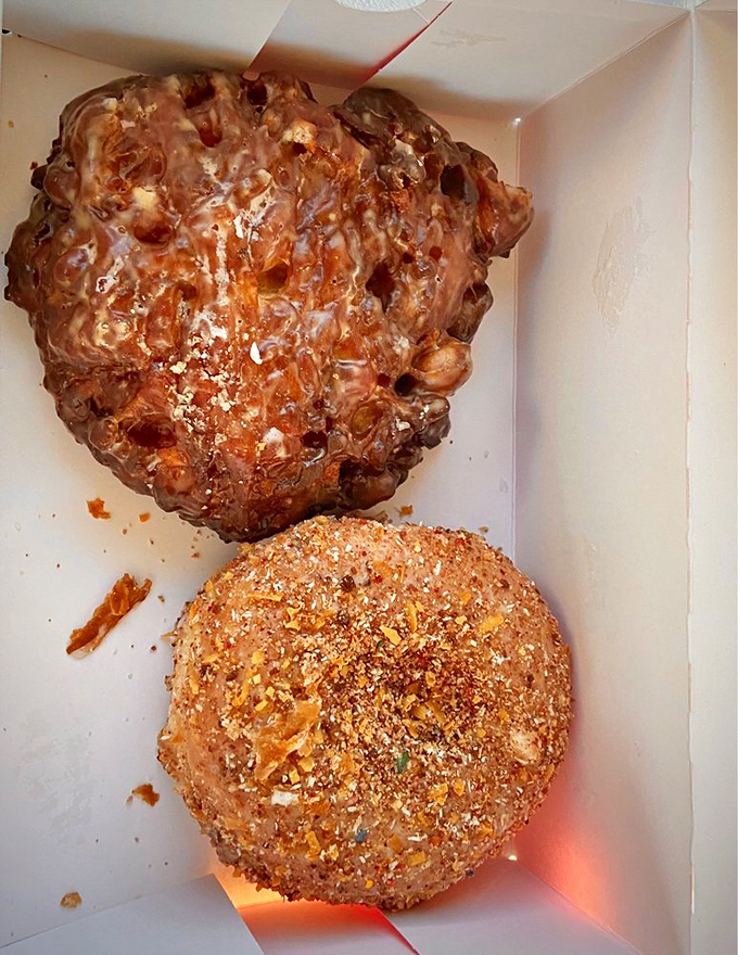 Textural nirvana in pastry form. The apple fritter's craggy landscape sits beside its cinnamon-crusted companion like Colorado's own edible mountain range.
