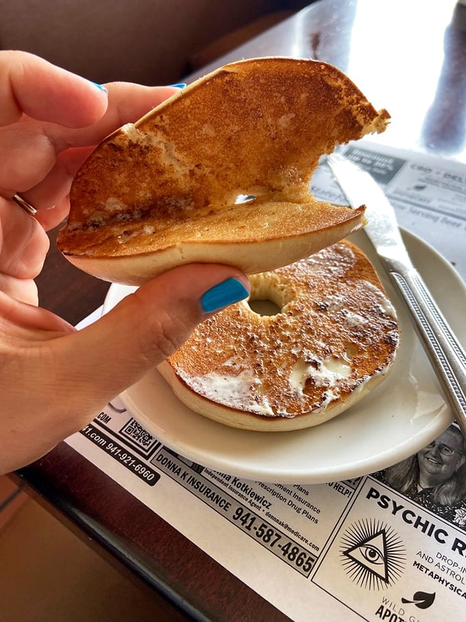 A perfectly toasted bagel that proves simple pleasures are often the most satisfying. The blue nail polish adds a pop of Florida flair!